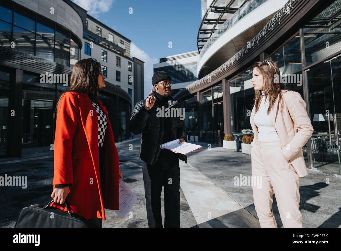 Three diverse business partners walking outside office buildings Stock ...