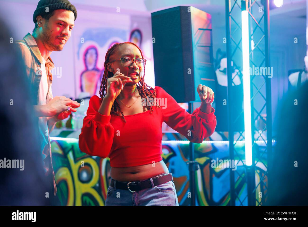 African american young woman dancing and partying in nightclub. Diverse ...