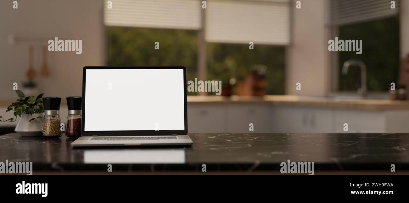 A white-screen laptop computer mockup on a black marble kitchen island ...