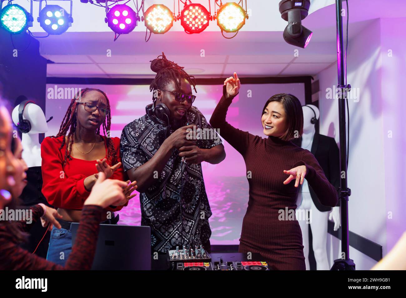 Band frontman singing and diverse women dancing on stage at discotheque ...