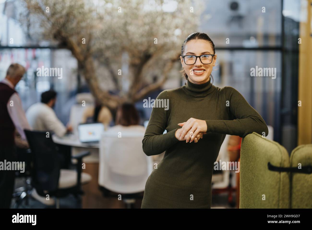 Successful woman standing proudly in a modern office, posing and ...