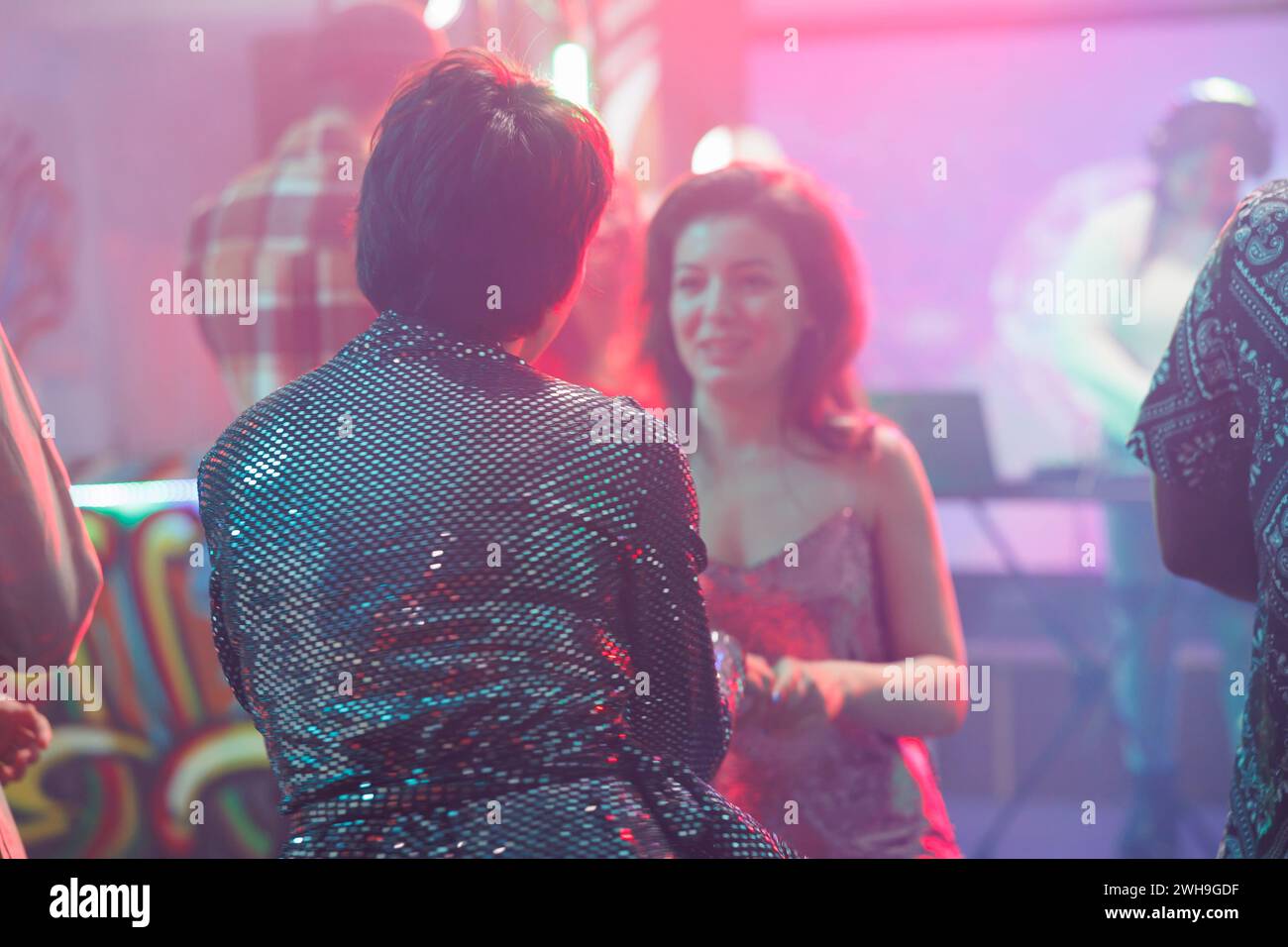 Women talking while relaxing at discotheque party in nightclub ...