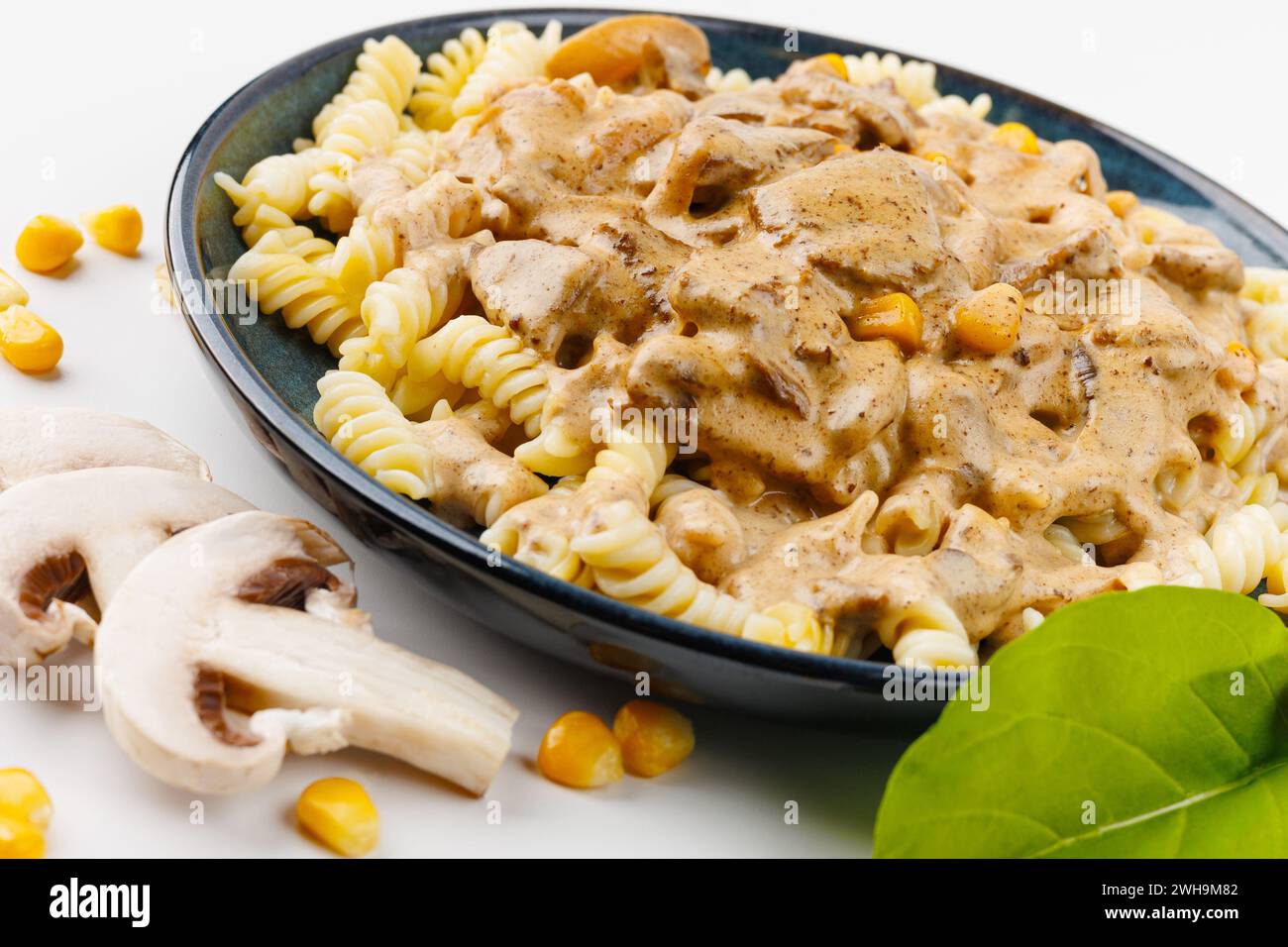 Pasta with cream sauce, mushrooms and corn on a white background Stock ...