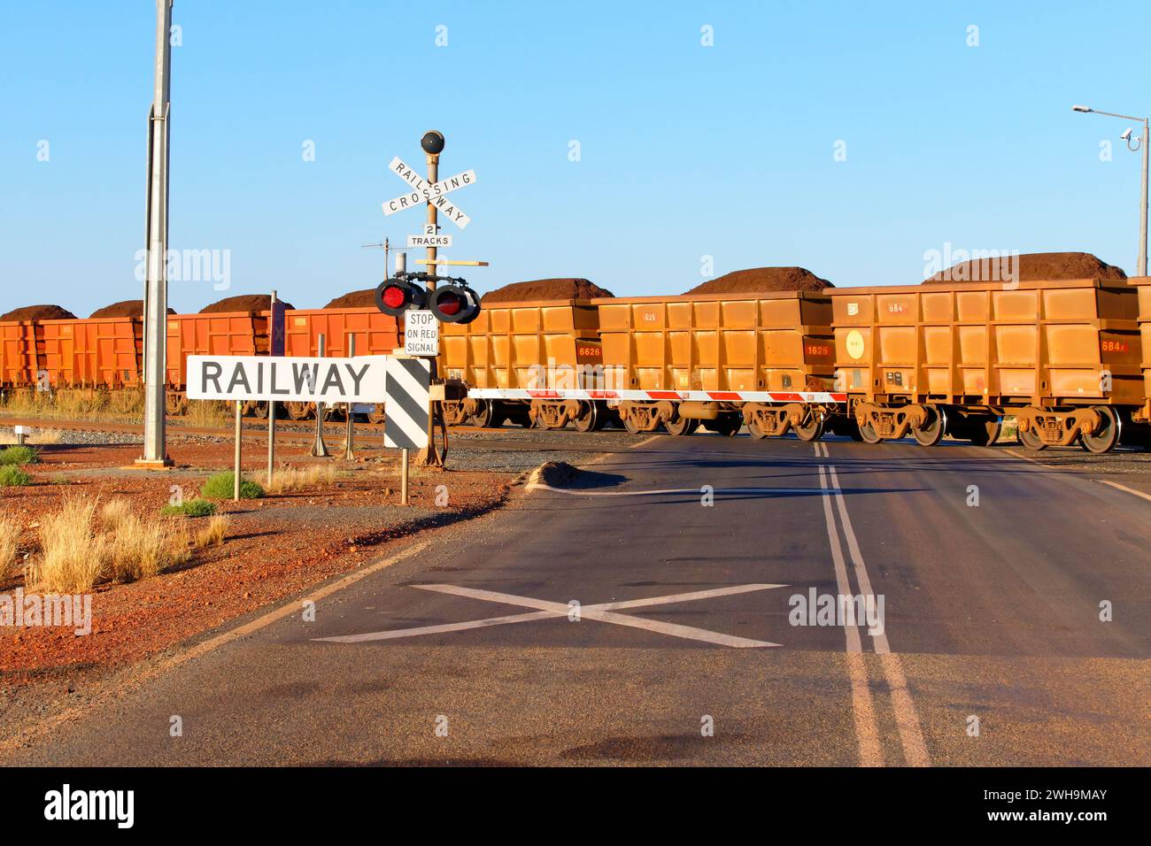 Full iron ore railway carriages and level crossing, Pilbara, Western ...