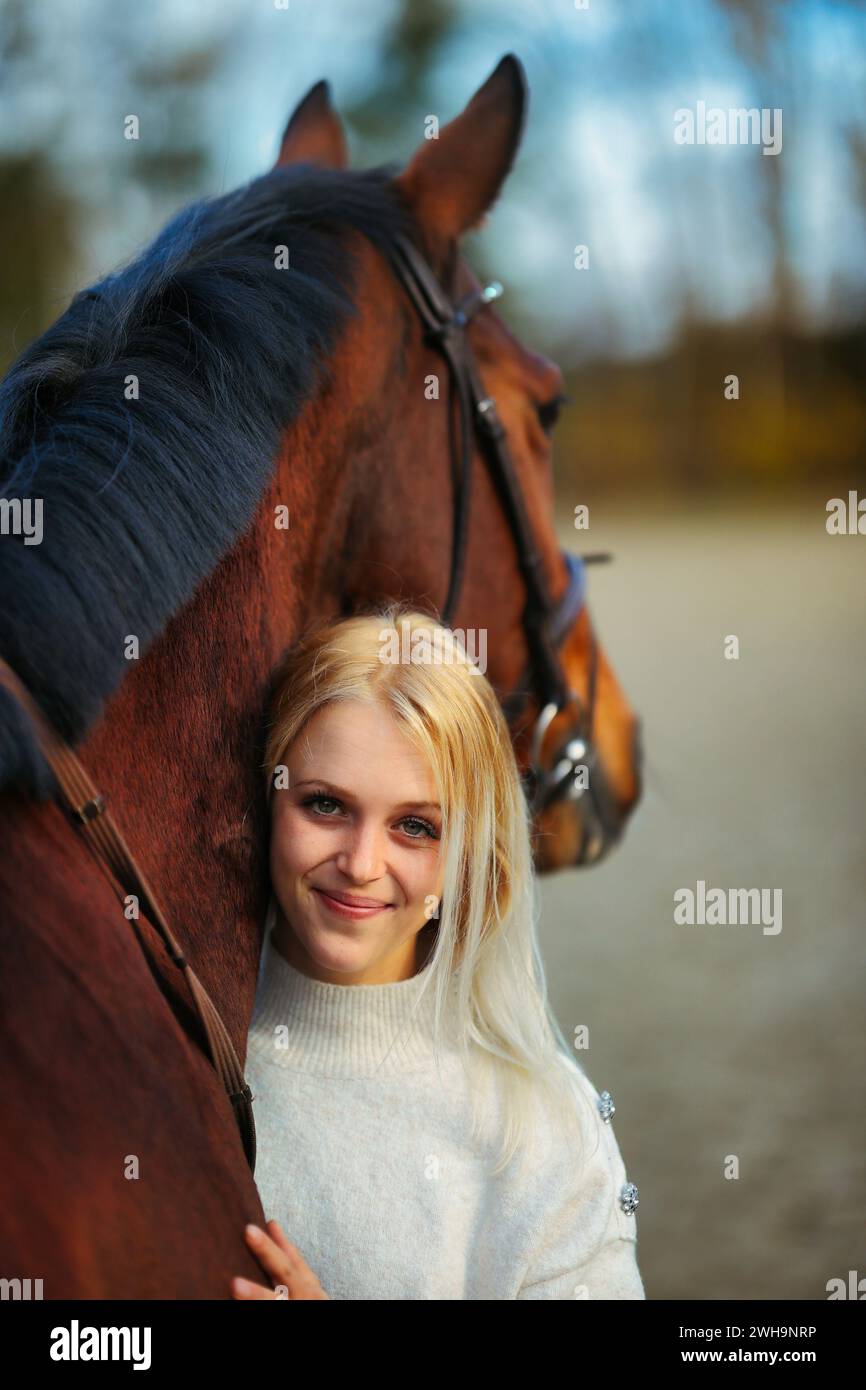 Young woman in portraits with her horse at the riding arena in ...