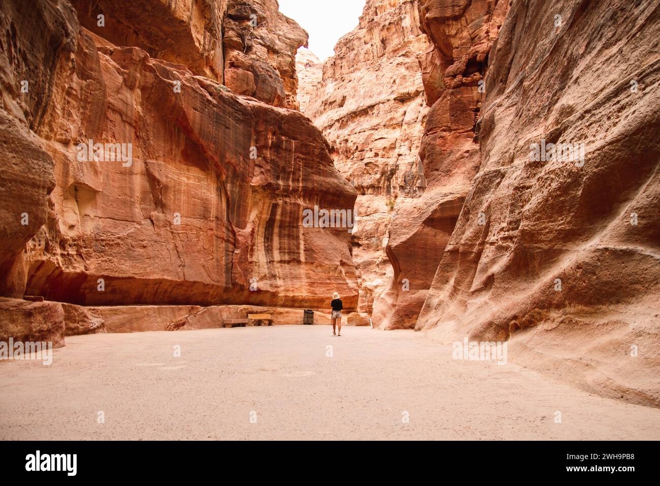 Caucasian tourist woman walk at Petra entrance al-siq tunnels ...