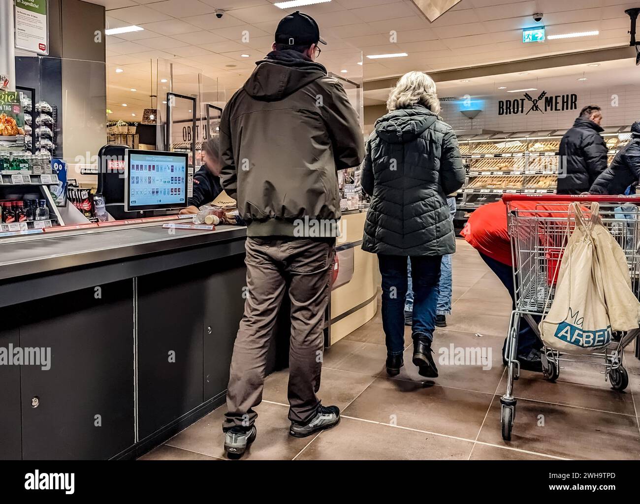 Hamburg, Germany. 03rd Feb, 2024. Customers waiting at the checkout in ...