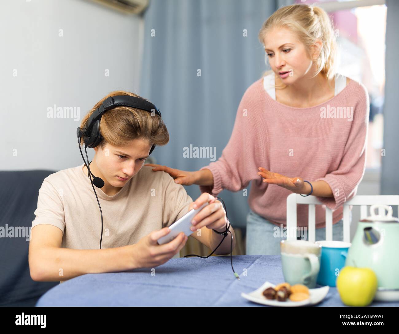 Mother asking for attention of her teenager son Stock Photo - Alamy