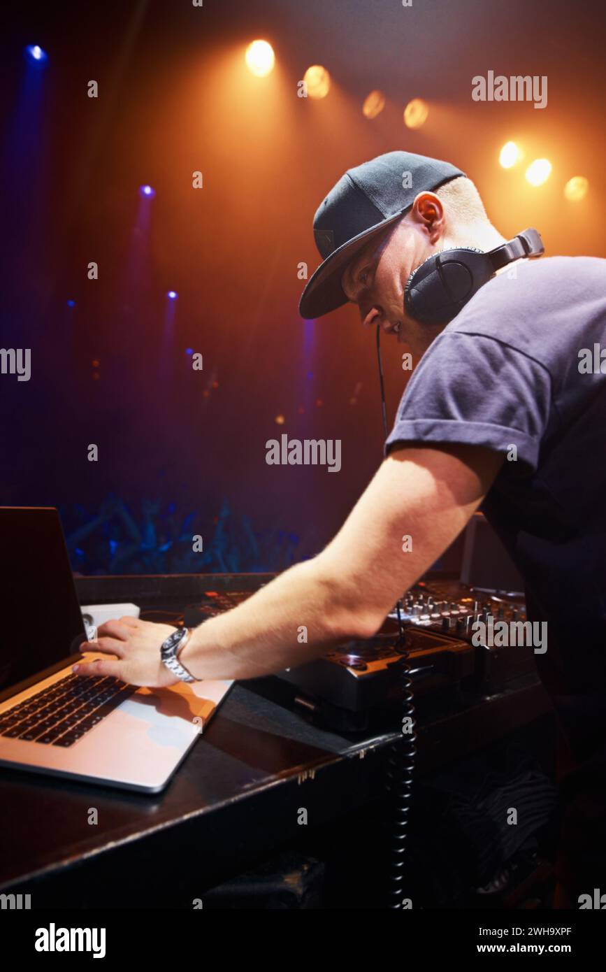 DJ, man and laptop at nightclub for concert with spotlights, turntables ...