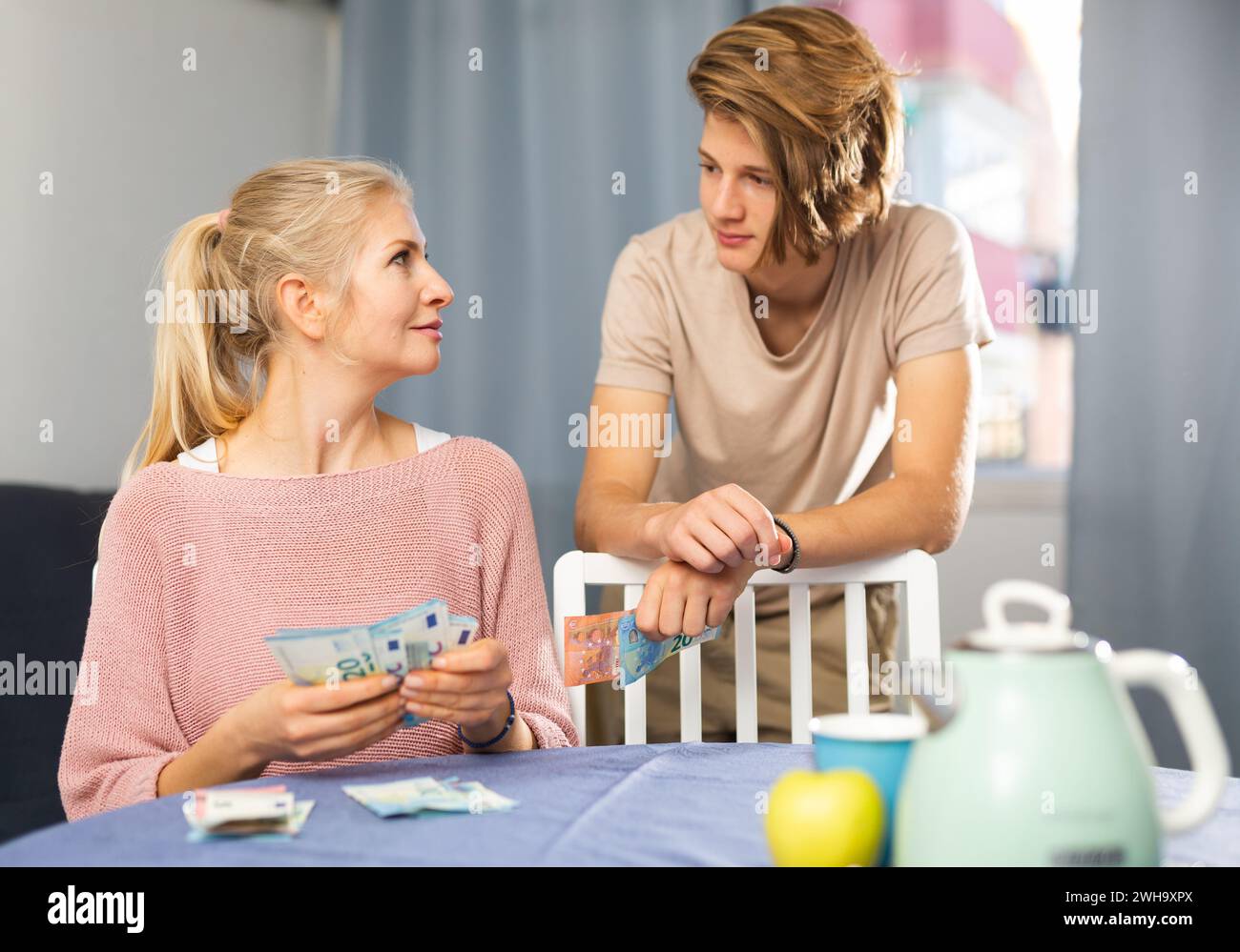 Mother giving some cash her teenager son Stock Photo - Alamy