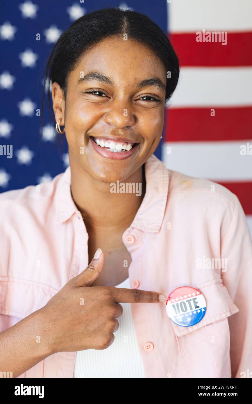 Biracial woman proudly displays Vote badge by American flag Stock Photo ...