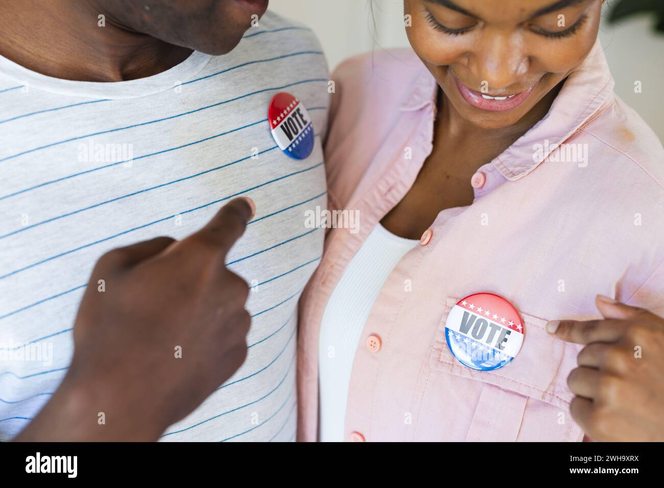 Biracial woman and African American man show their 'Vote' badges Stock ...
