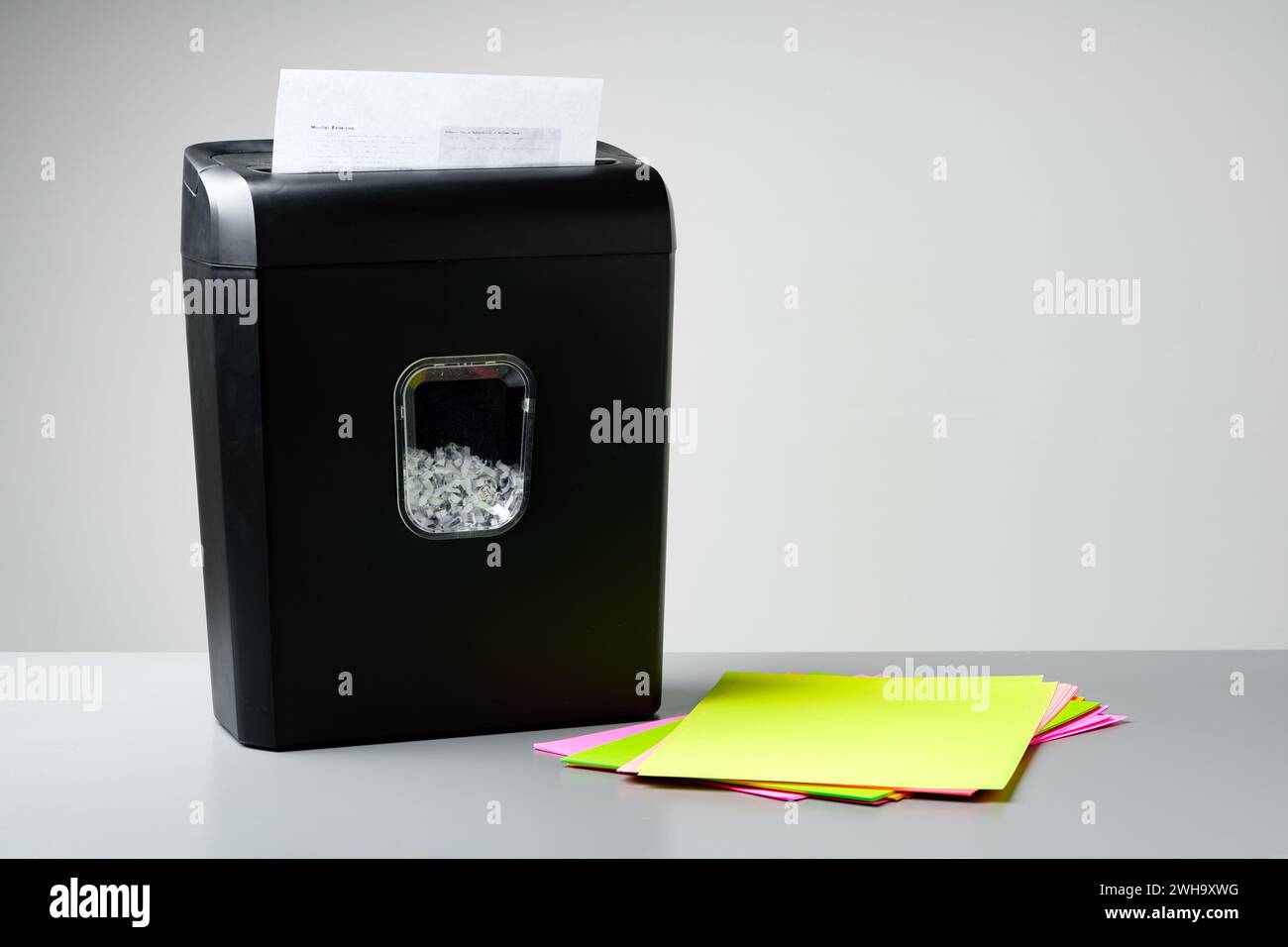 Office paper shredder on table against gray background Stock Photo - Alamy
