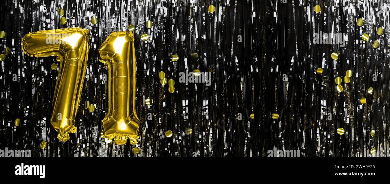 Gold foil balloon number number 71 on a background of black tinsel ...
