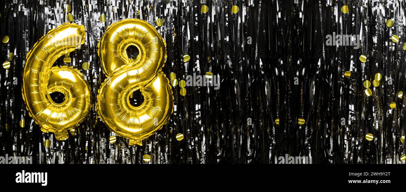 Gold foil balloon number number 68 on a background of black tinsel ...