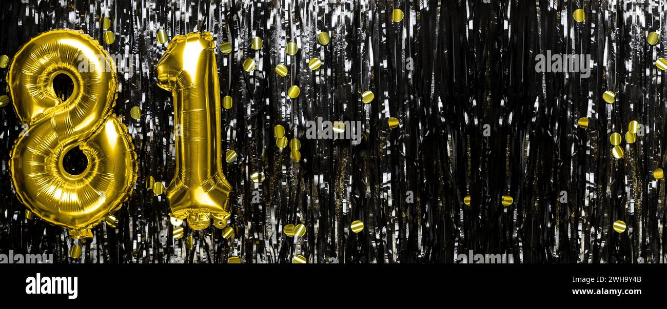 Gold foil balloon number number 81 on a background of black tinsel ...