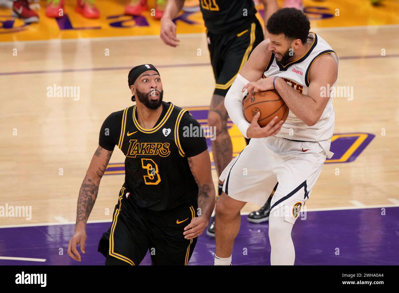 Denver Nuggets guard Jamal Murray controls a rebound next to Los ...