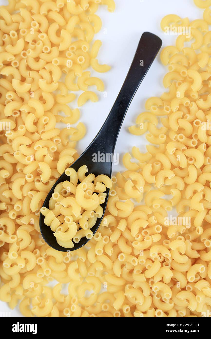 Top View Dried Macaroni Pasta on Black Spoon Stock Photo - Alamy