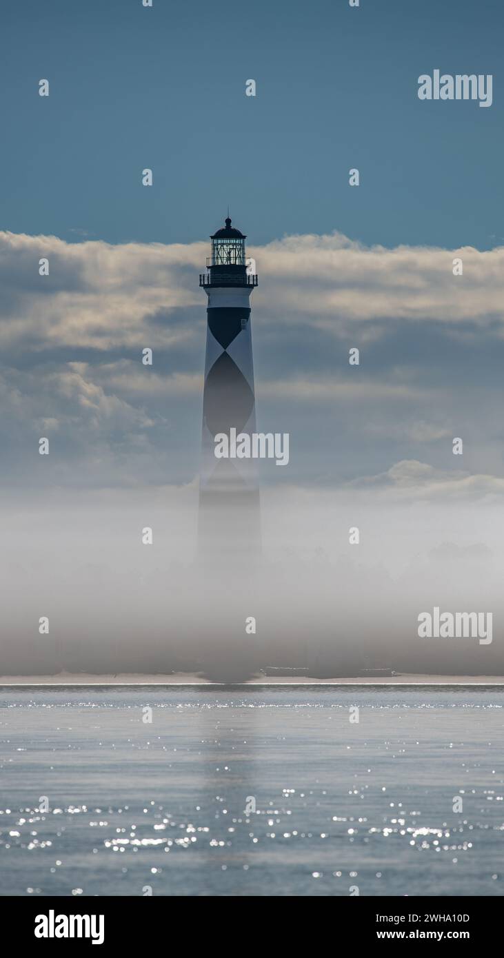 A vertical of a lighthouse surrounded by mist and water Stock Photo - Alamy