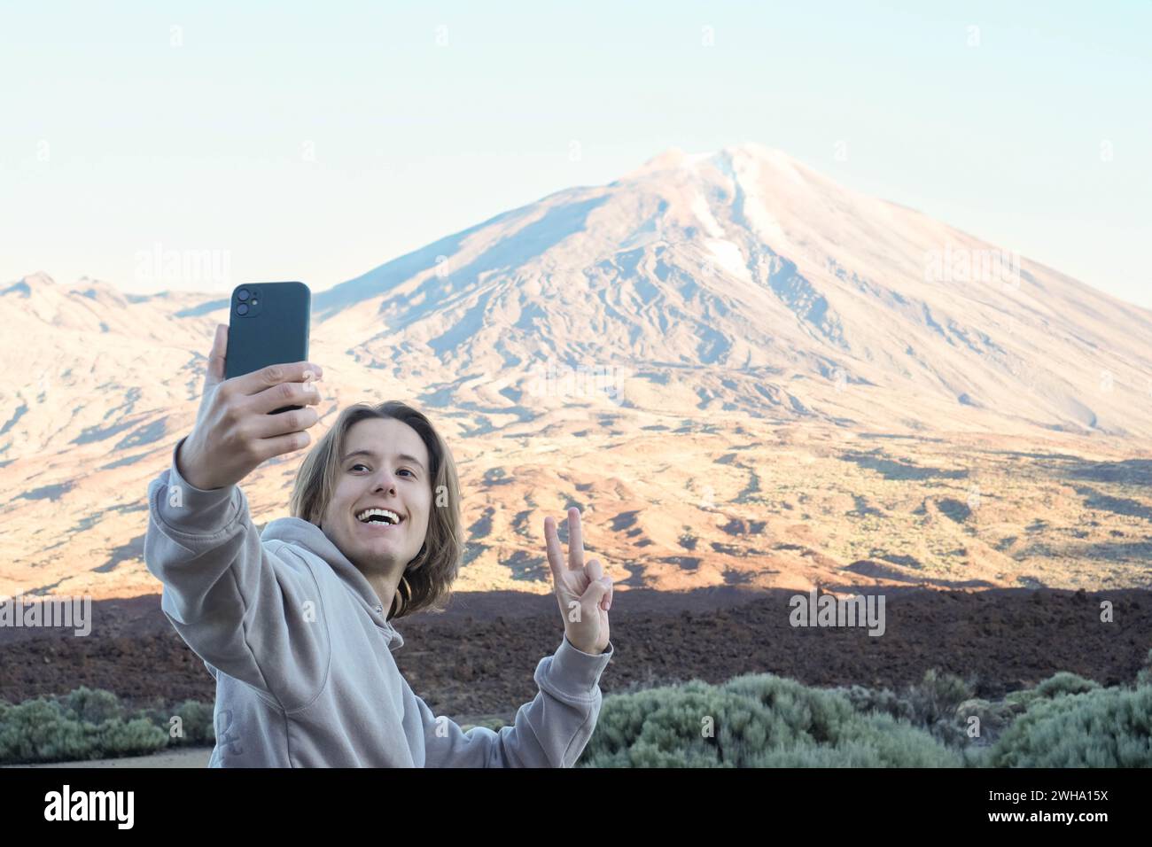 A man capturing a self-portrait with the majestic Teide mountain ...