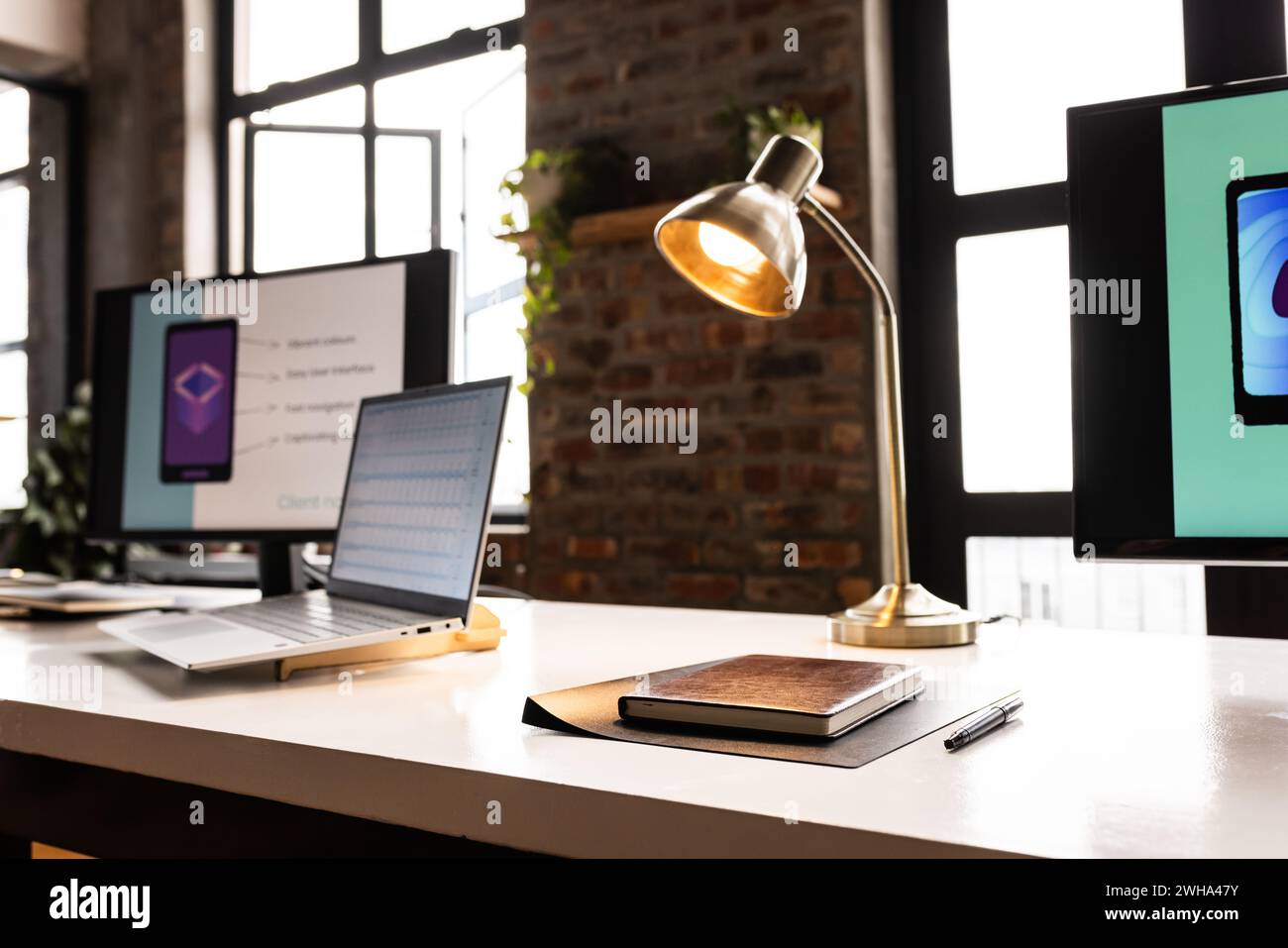 A modern casual business office setup features a laptop and desktop monitor Stock Photo - Alamy