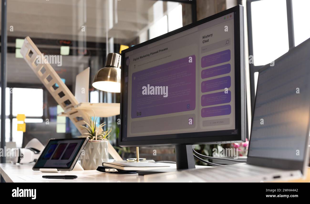 A modern casual business office setup features a computer monitor displaying a user interface ...
