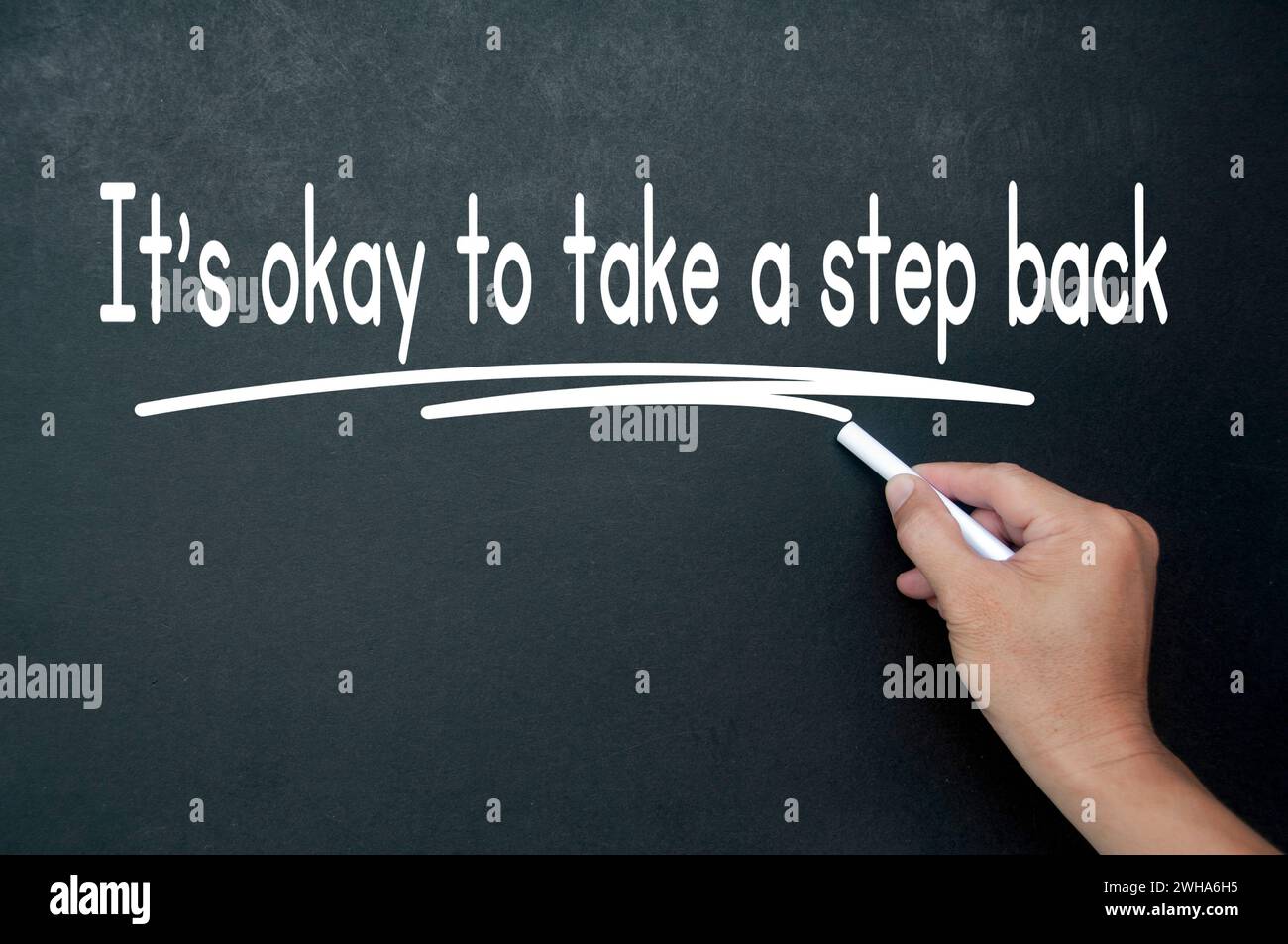 Hand writing It is okay to take as step back affirmation on black board ...