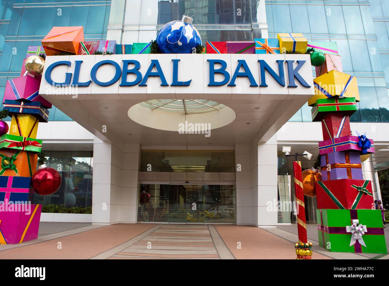 A global bank sign in Panama City is surrounded by stacks of Christmas ...