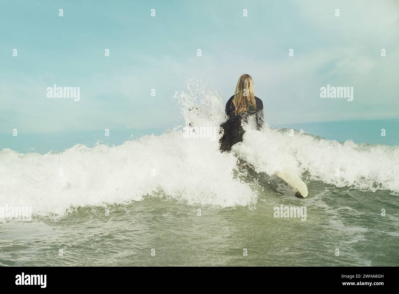 Ocean, wave and splash with surfer woman in wetsuit for sports, fitness ...