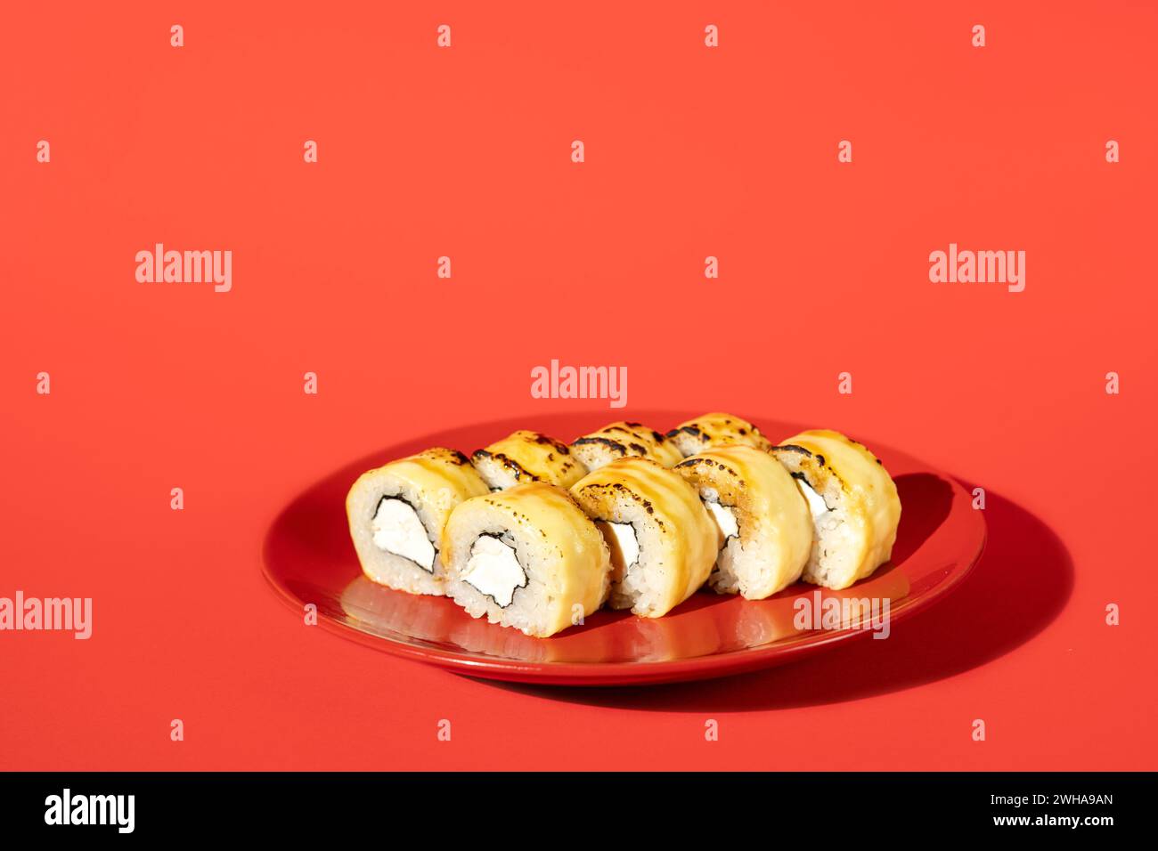 Philadelphia sushi on a red plate isolated on a dark red background ...