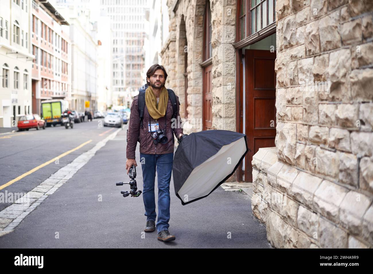 Camera, equipment and photographer in city for photoshoot with lighting ...