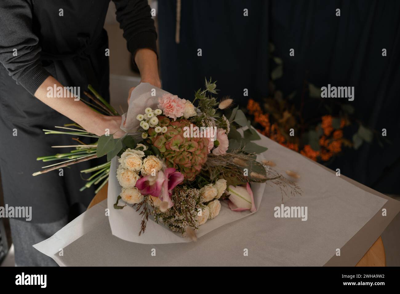Female Florist making fashion modern bouquet of different flowers, top ...