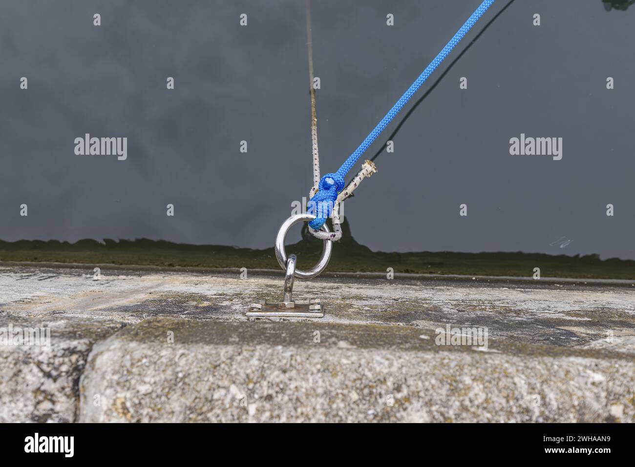 Picture of an eyelet for mooring ships at the pier with a line in front ...