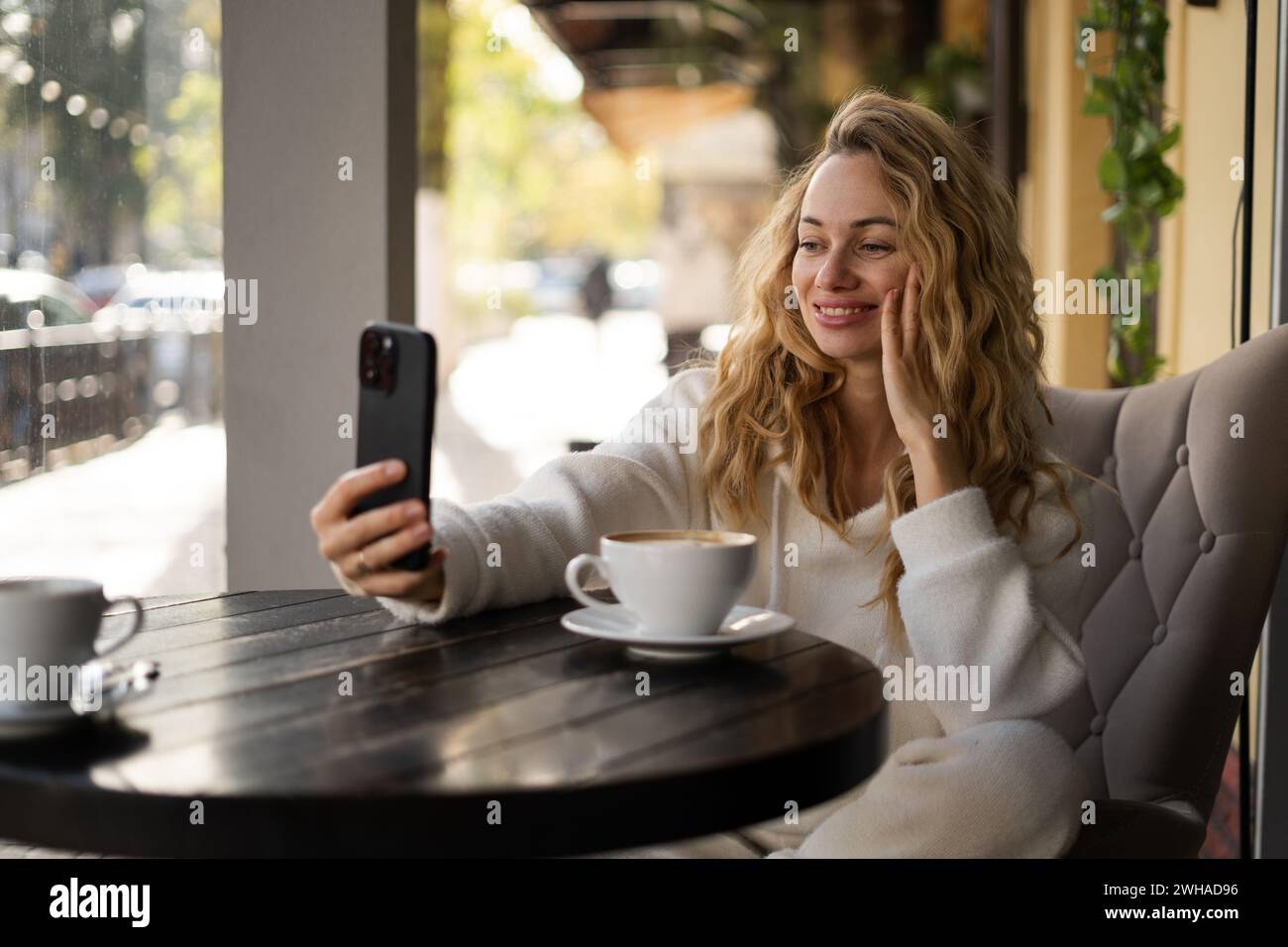 Selfie in a coffee shop. Relaxed female person and happy lady with ...