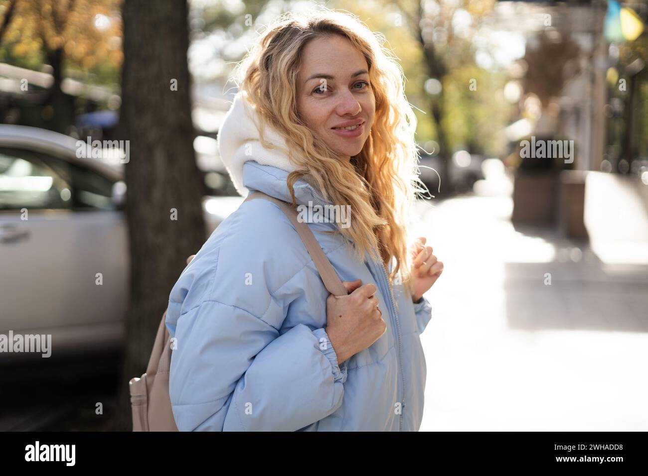 Blonde cute woman tourist walking on the street, spring fashion style ...