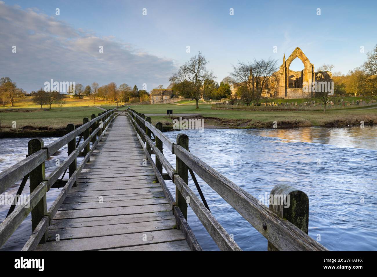 View of Bolton Abbey, from a foot bridge over the River Wharfe in the ...