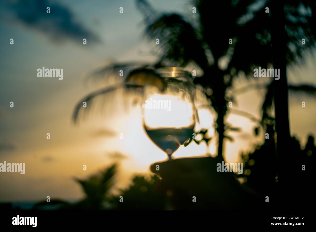 A captivating moment holding a cocktail glass in the Maldivian sunset ...