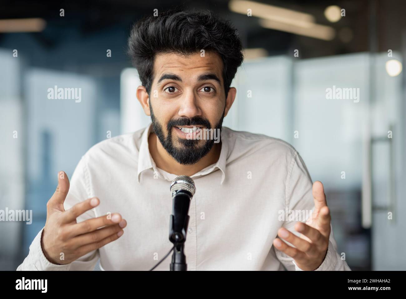 Indian businessman with a beard engaging an audience, speaking into a ...
