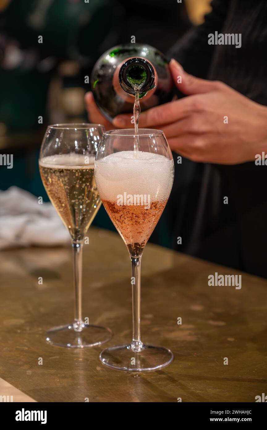 Pouring and tasting of dry sparkling wine champagne on winter weekend ...