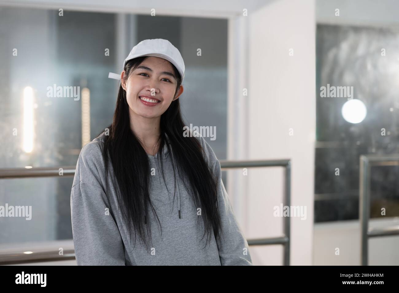Portrait attractive female dancer wearing hoodie standing dance studio ...