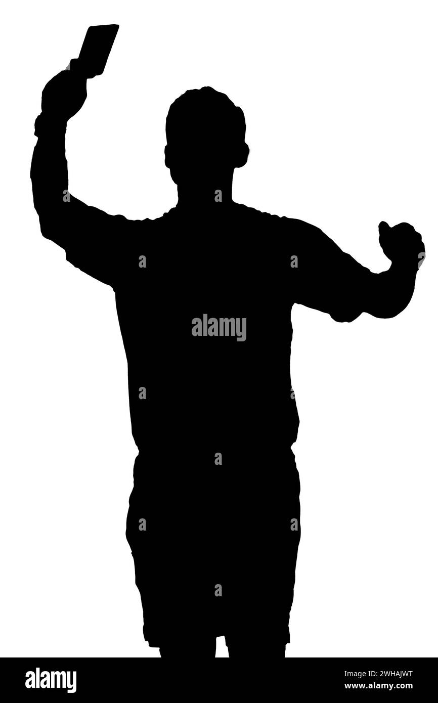 Silhouette of a referee in a ball game holding up a red card against a ...