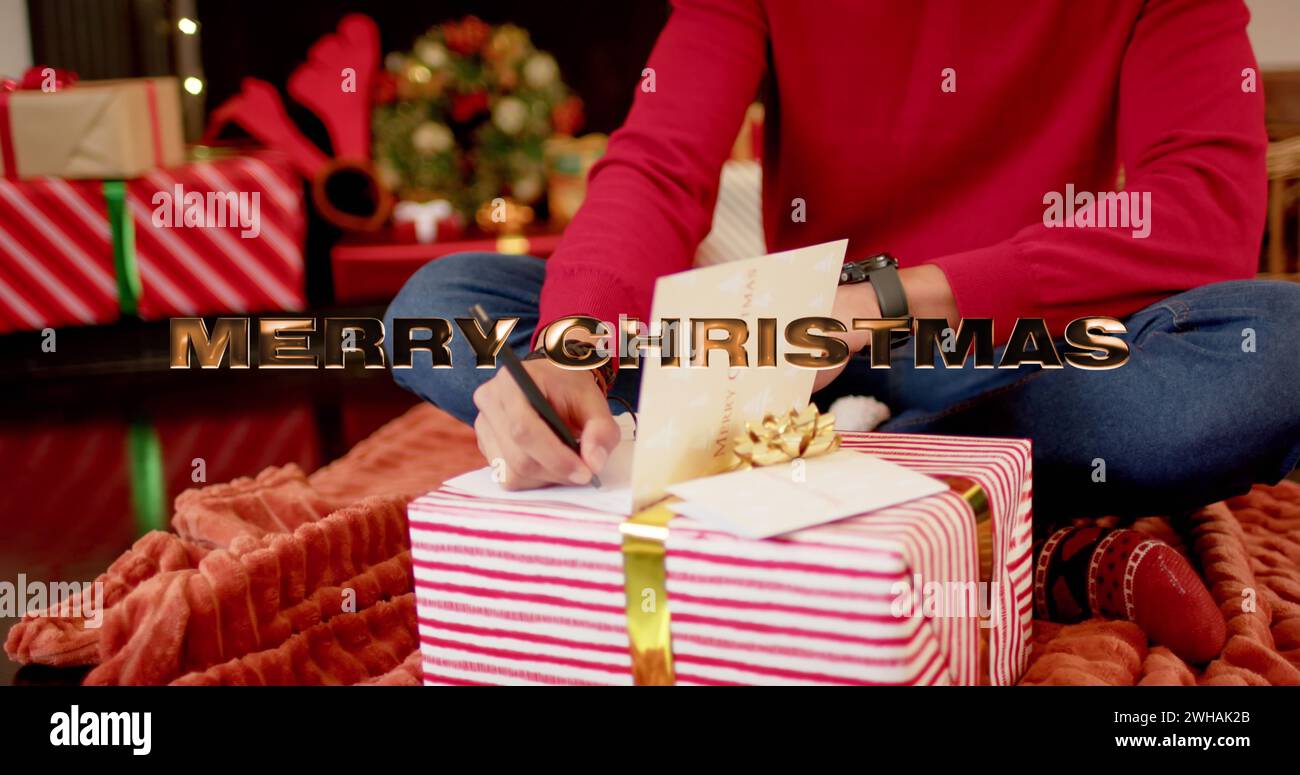 Image of happy holidays text over caucasian man writing christmas cards ...