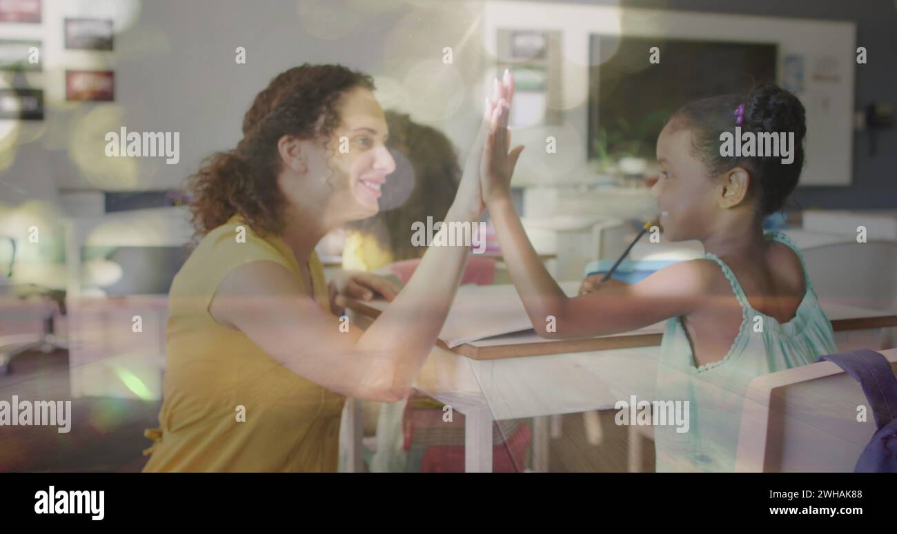 Image of bokeh lights over diverse female teacher and pupil high fiving ...