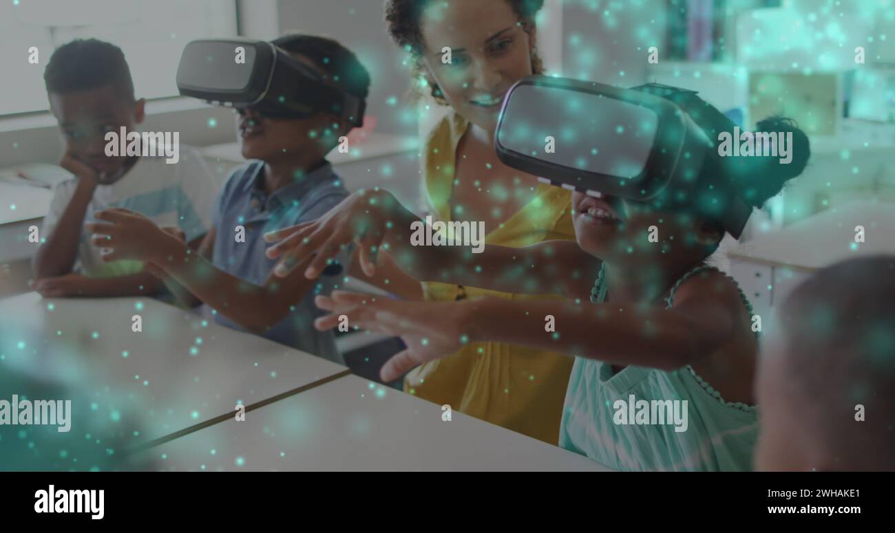 Image of particles of light over diverse female teacher and pupils in vr headsets in classroom ...