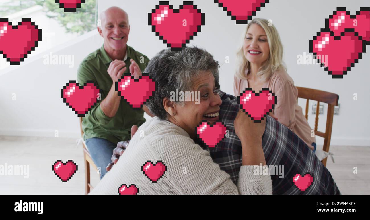 Image of hearts over diverse group of seniors embracing Stock Photo - Alamy