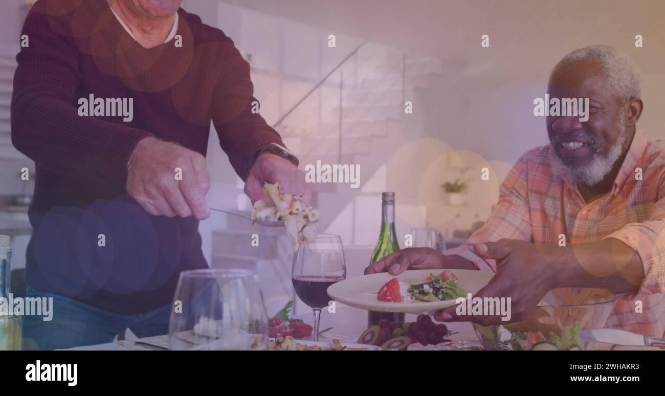 Image of light spots over diverse group of seniors eating Stock Photo ...