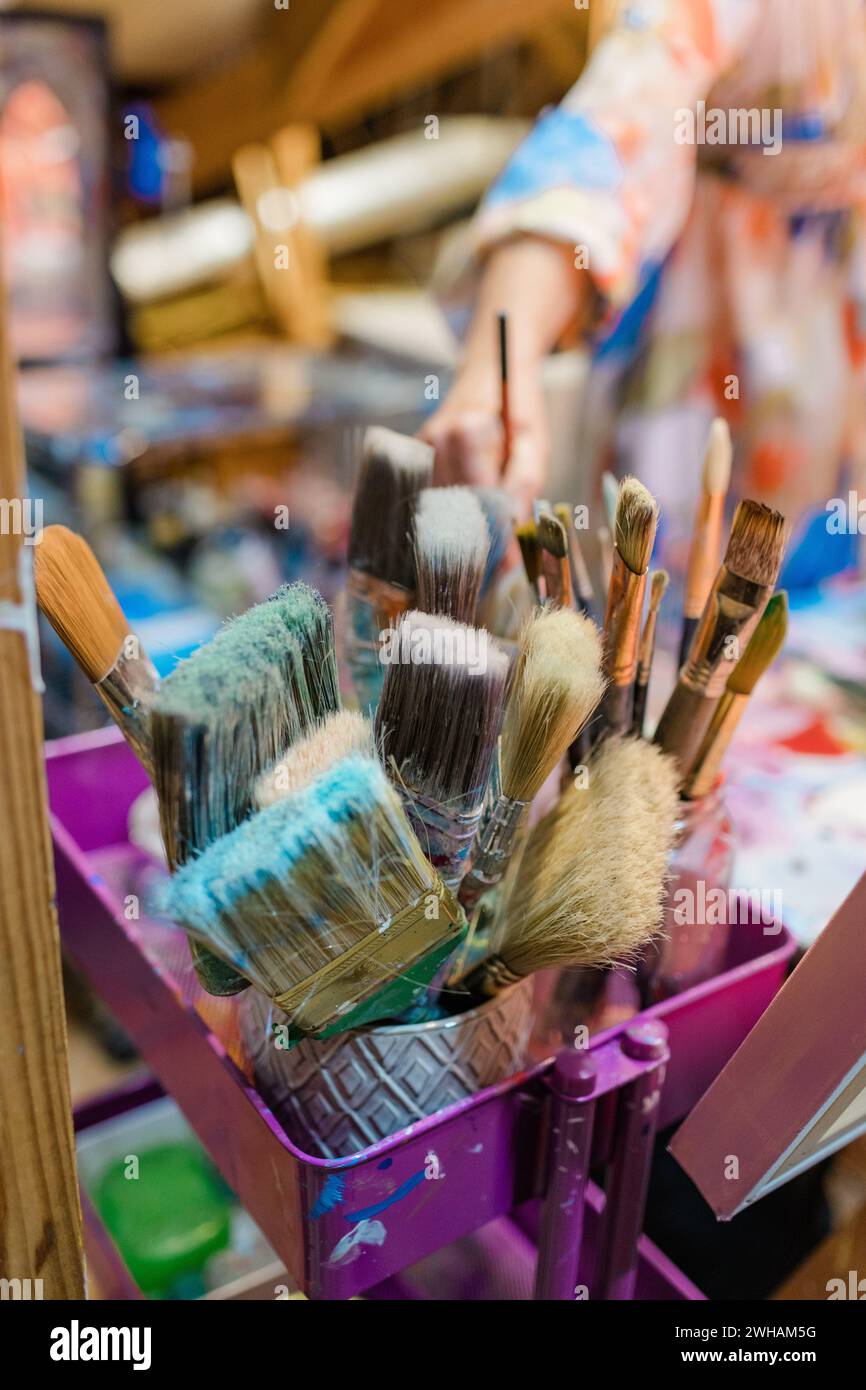 Used paint brushes in a bucket in an artist's studio Stock Photo - Alamy