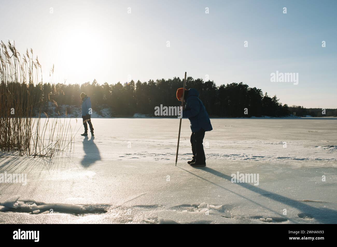 boy and his father walking on frozen lake testing the ice Stock Photo ...