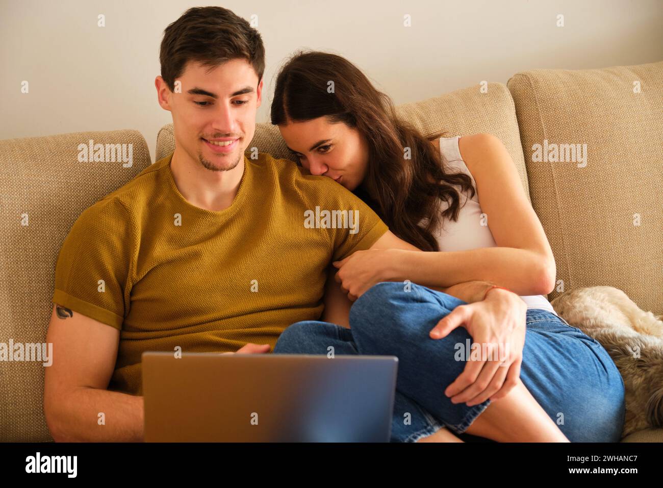 Spanish couple watch a movie on the laptop while hug and kiss Stock ...