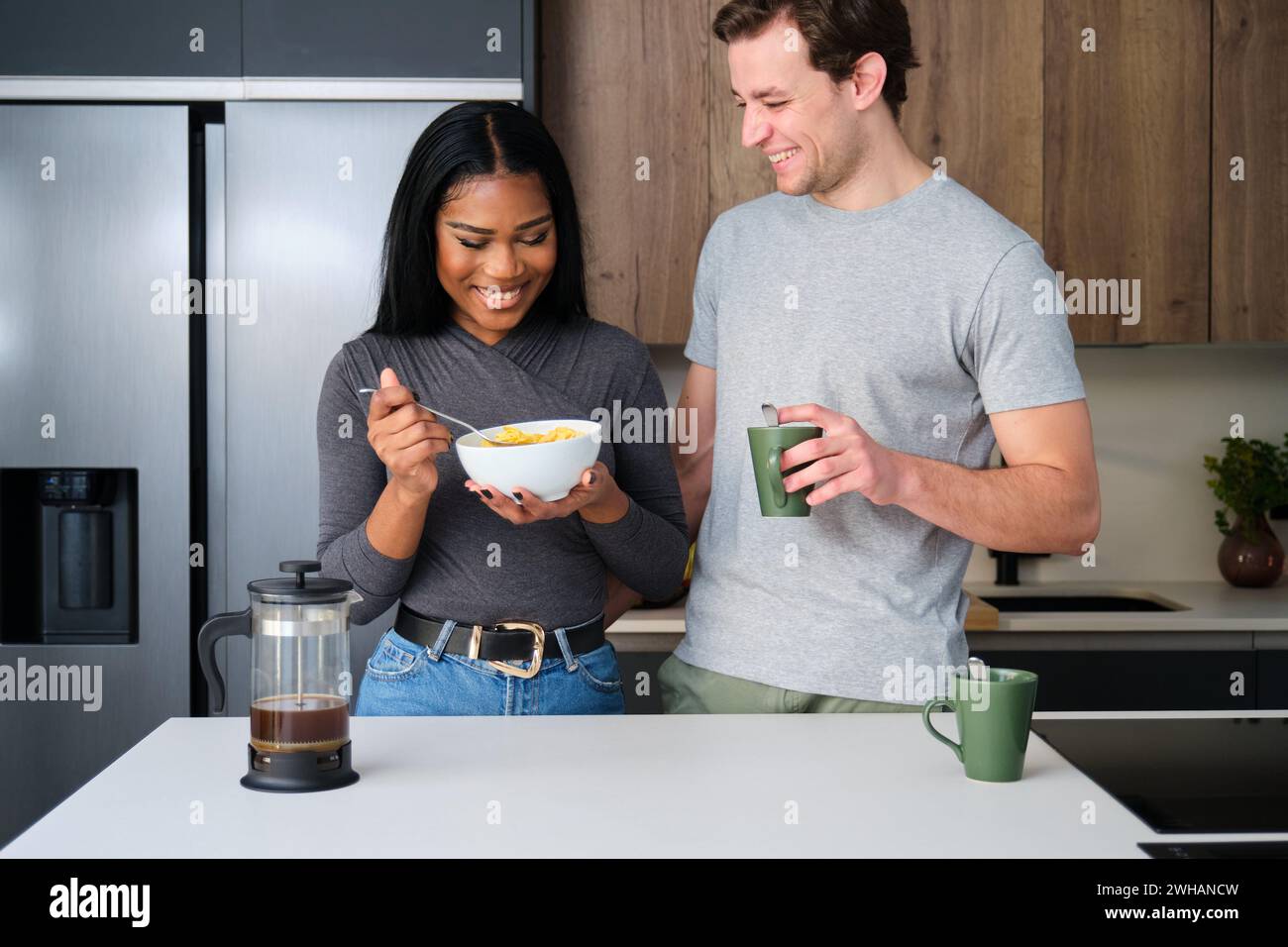 Multiethnic couple having fun while having breakfast at kitchen Stock ...